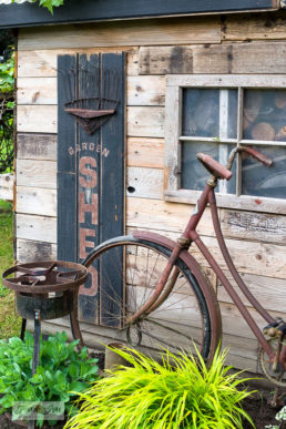 Rustic DIY garden shed sign with a rusty rake
